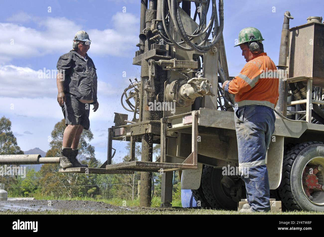 A drilling rig operator aims for an underground water supply near ...