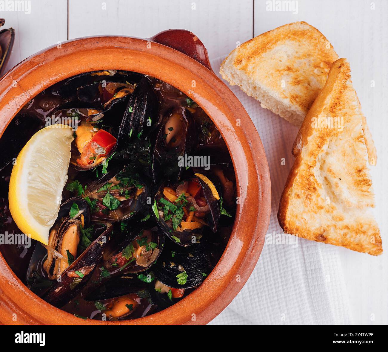 Mussels cooked in clay pot with toasted bread and lemon hi-res stock ...