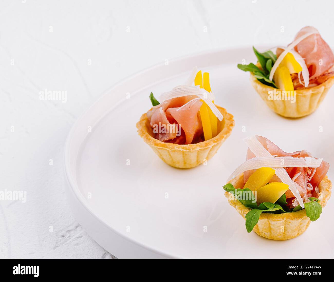 Elegant appetizers with prosciutto, melon, and arugula served on a ...