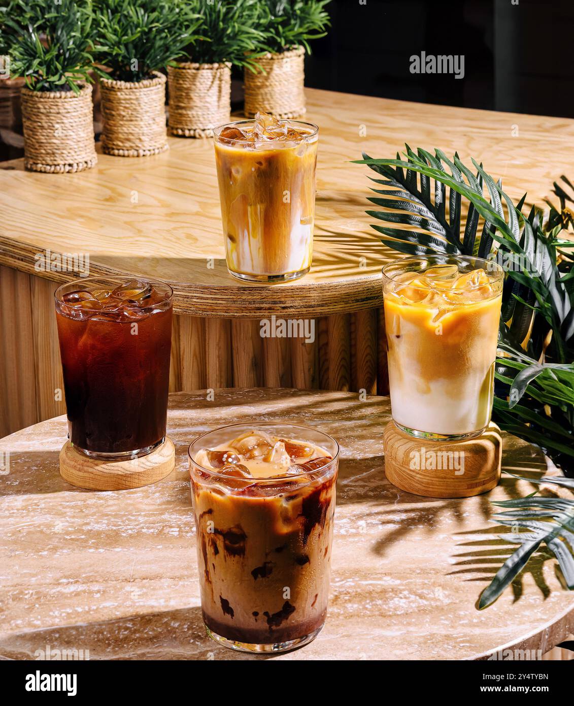 Four iced coffee drinks with various syrups and flavors are sitting on ...
