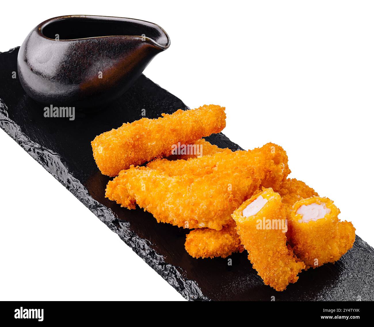 Deep fried breaded chicken strips with dipping sauce served on a black ...