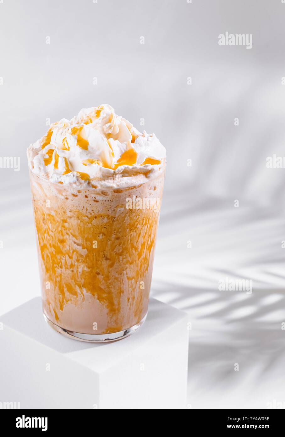 Iced coffee frappe with whipped cream and caramel drizzle on white ...