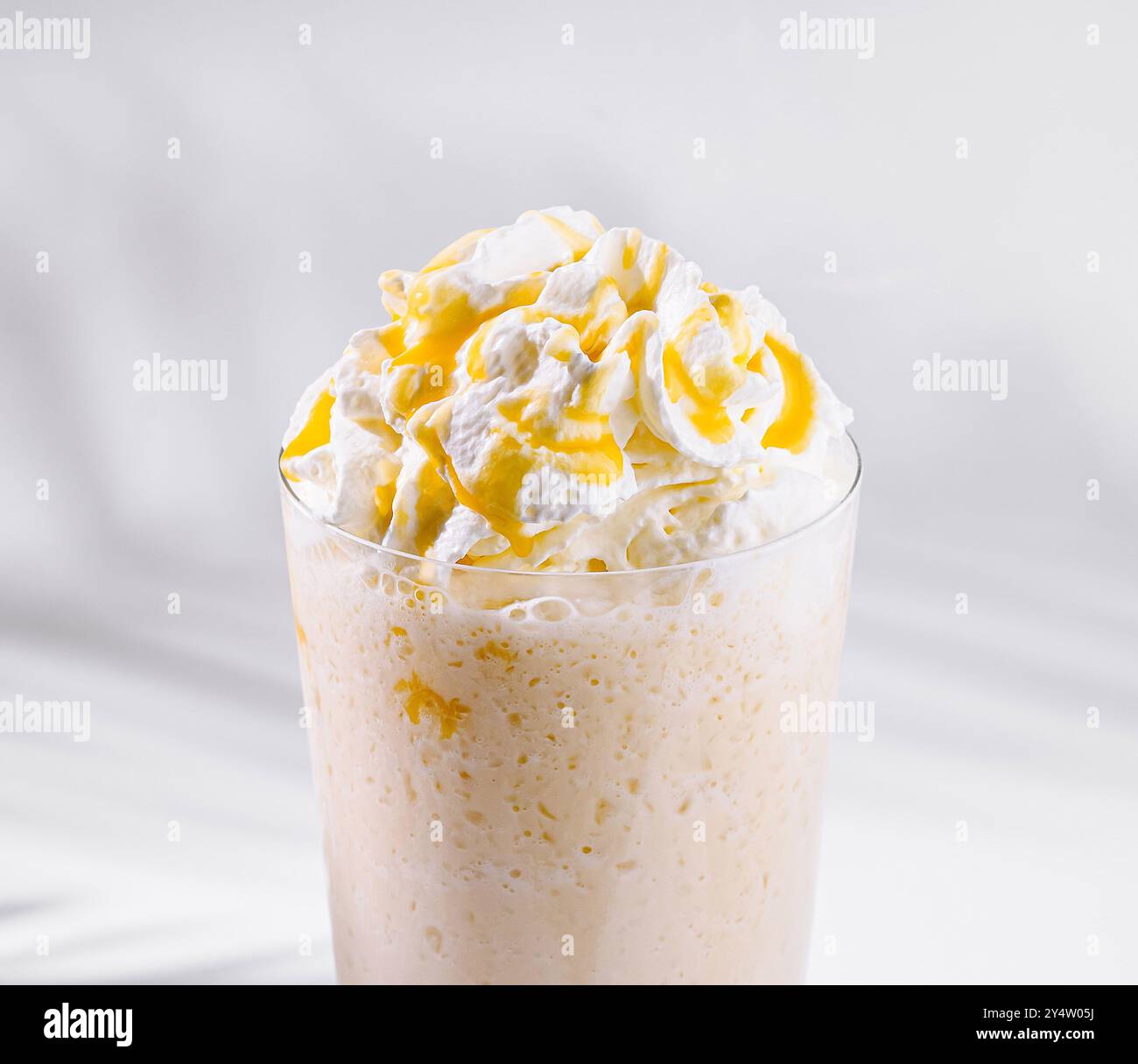 Caramel being poured on a delicious frappuccino with whipped cream in a ...