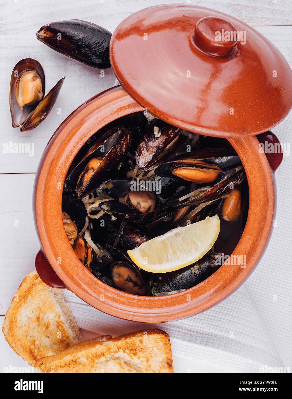 Mussels cooked in clay pot with toasted bread and lemon hi-res stock ...