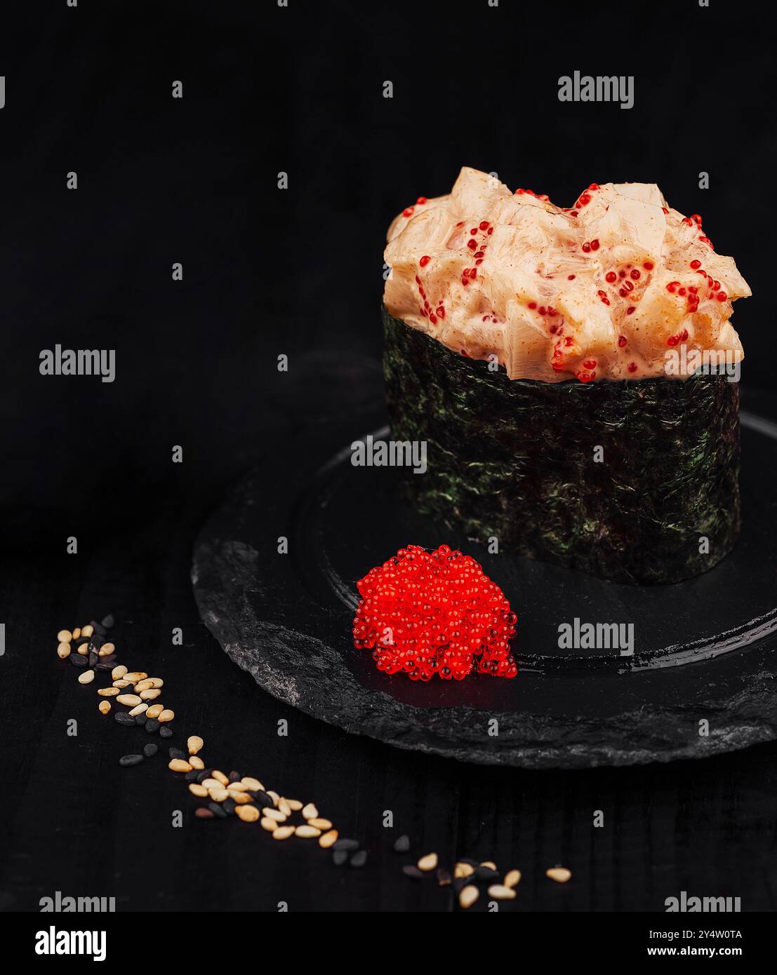Spicy gunkan maki sushi with tobiko and spicy sauce standing on black ...