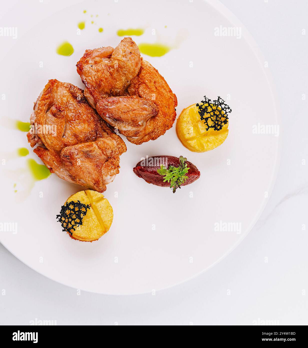 Elegant plating of fried chicken topped with caviar, served alongside ...