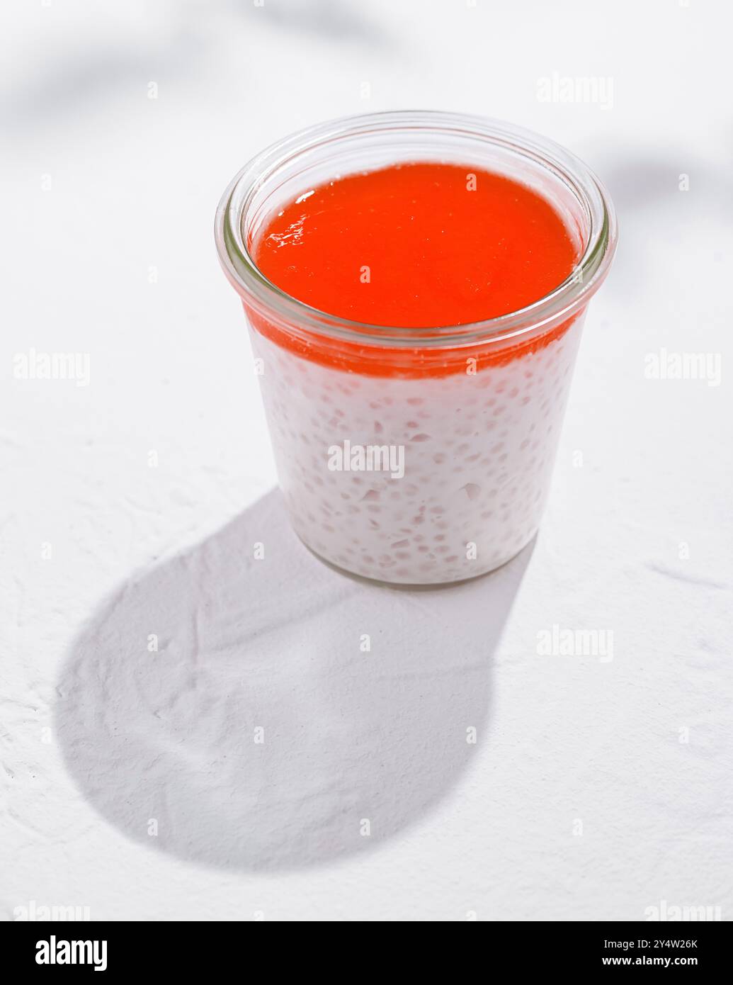Glass jar with healthy tapioca pudding dessert with strawberry puree ...