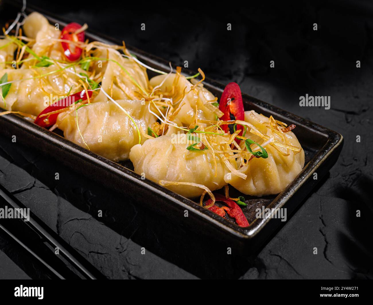 Savory presentation of steamed asian dumplings adorned with garnishes ...