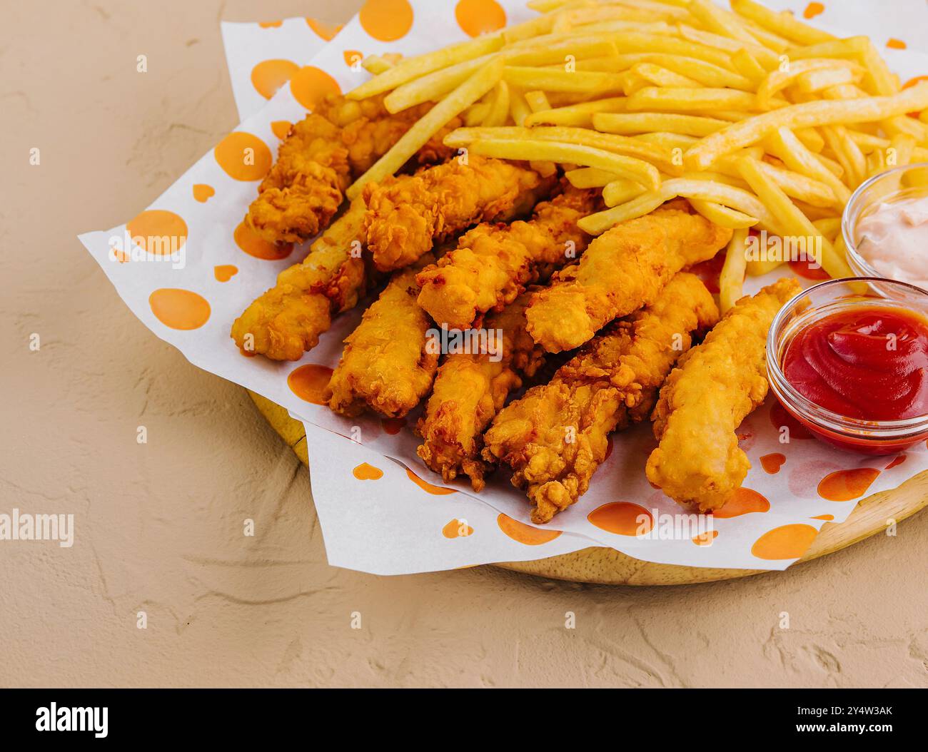 Golden fried chicken strips with french fries, ketchup, and mayonnaise ...