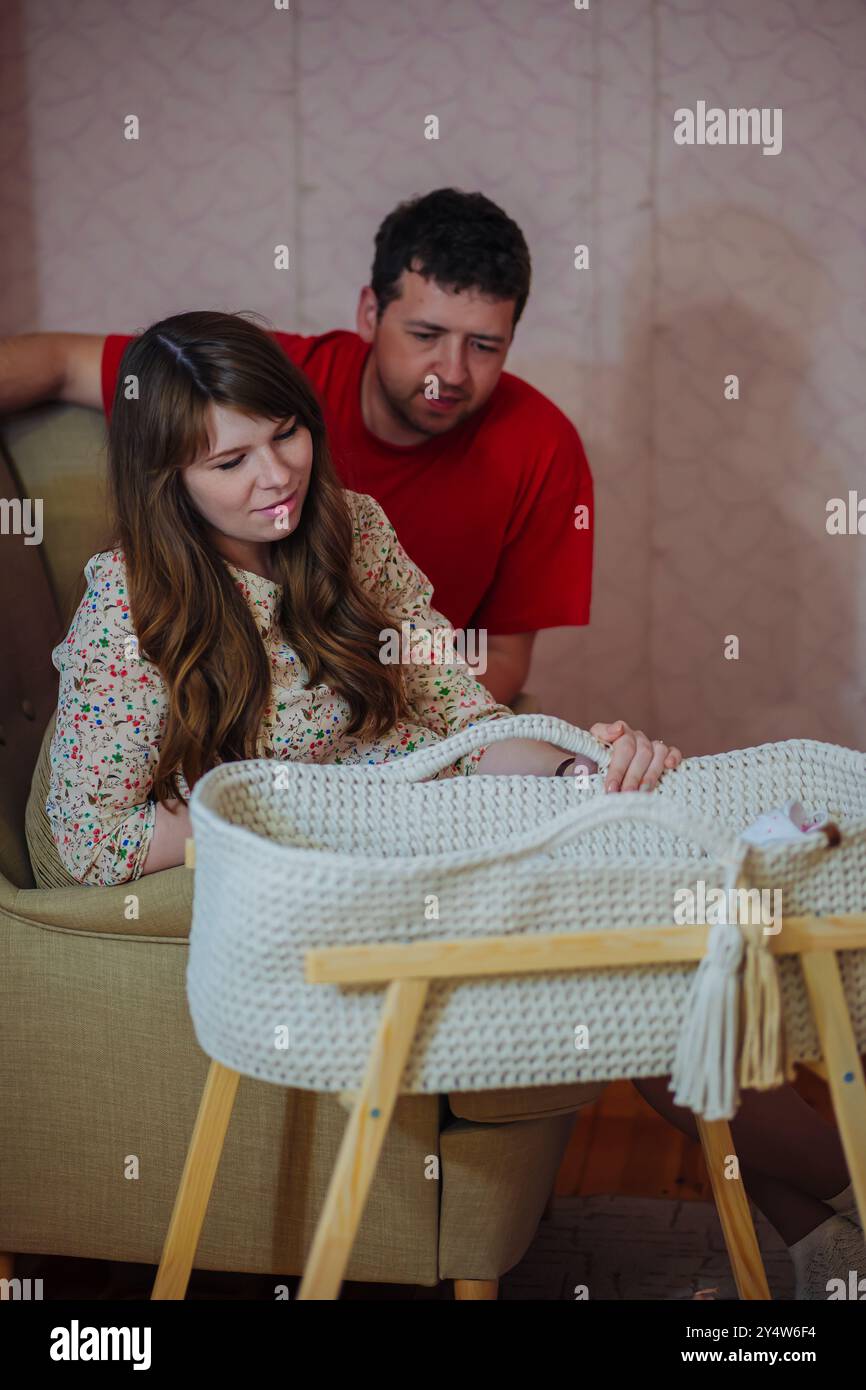 Happy parents watching over baby son sleeping in crib at home in ...
