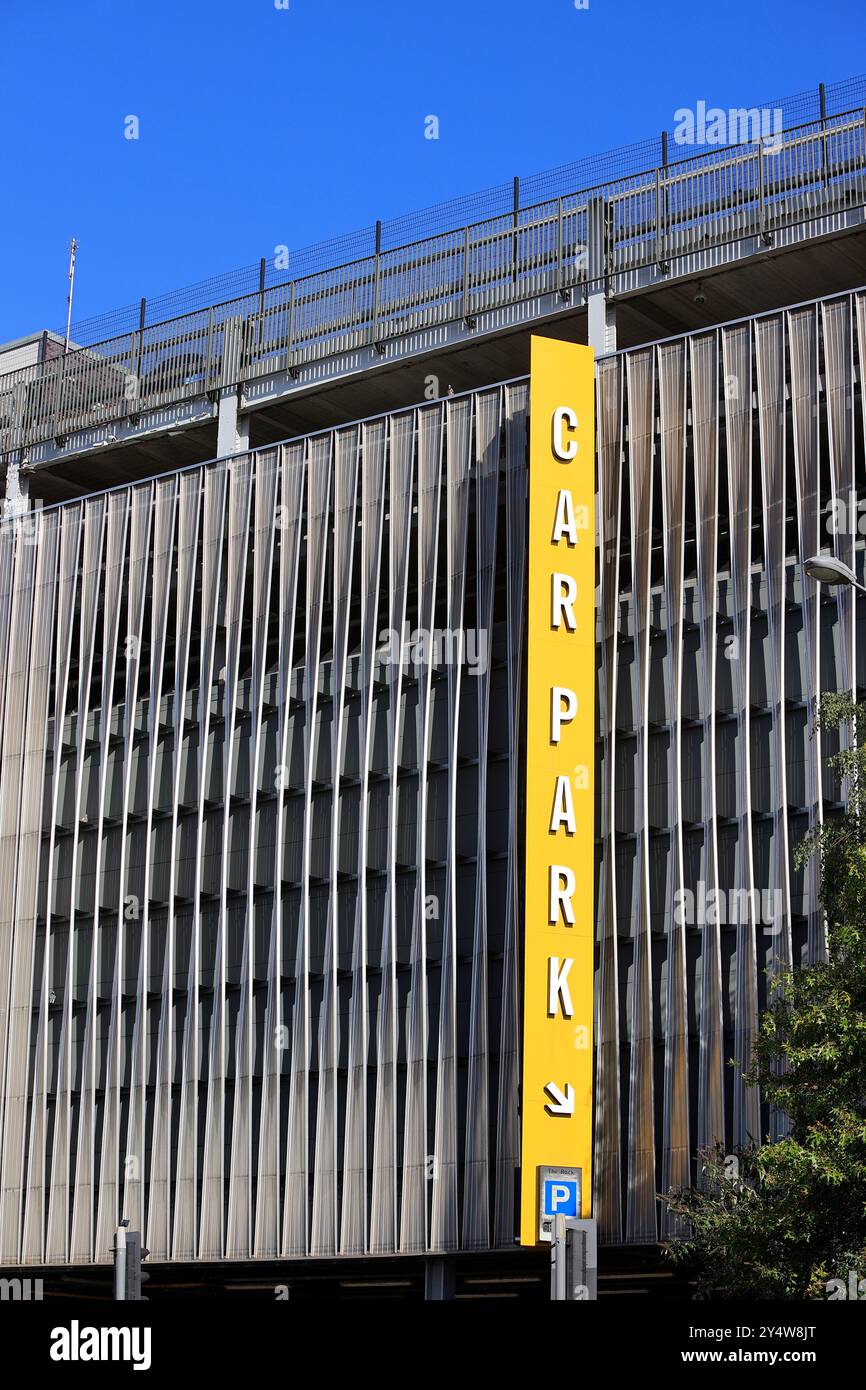 Yellow vertical car park sign with white letters mounted on Multi ...