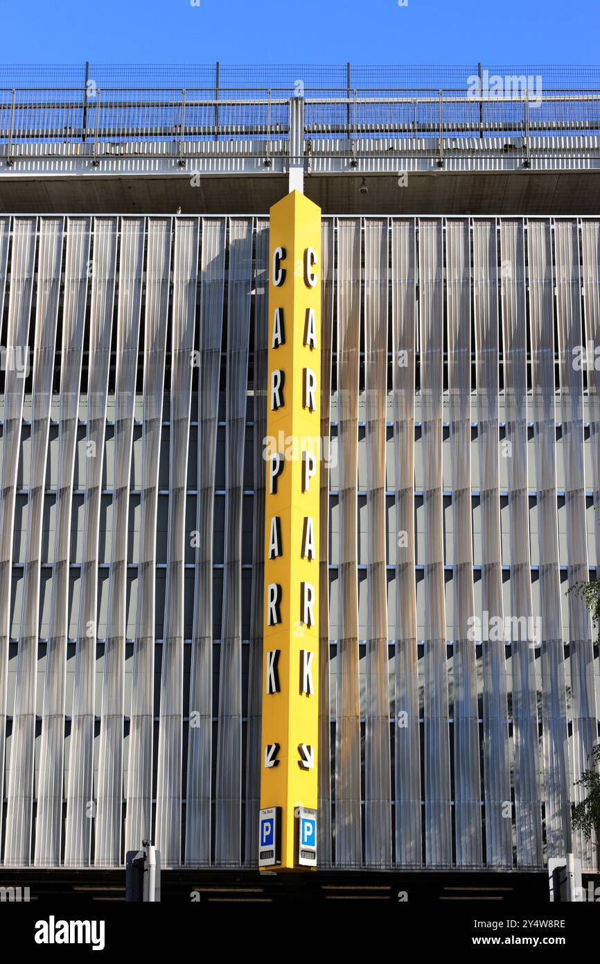 Yellow vertical car park sign with white letters mounted on Multi ...