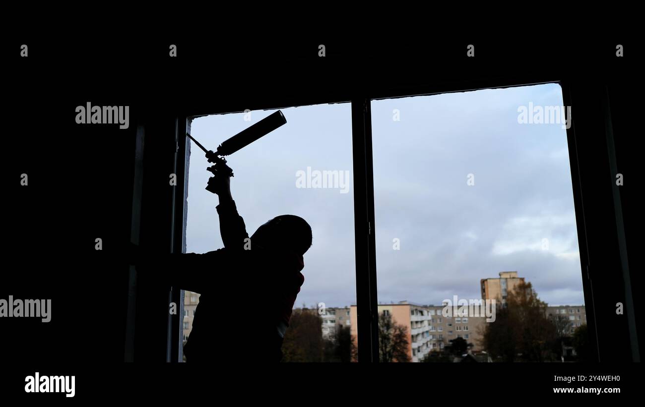 Construction worker is installing a window in a building using ...