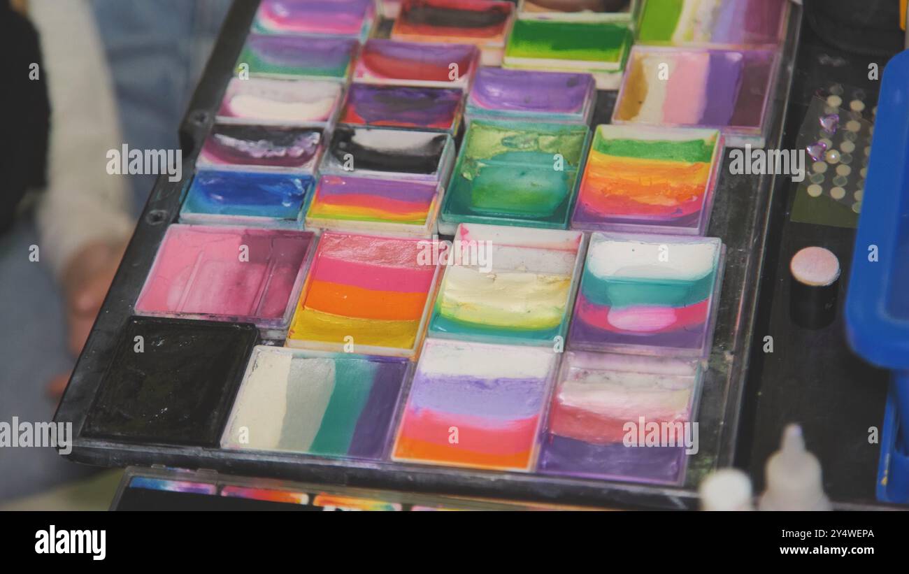 Open palette of vibrant face paints on a table, ready to transform ...