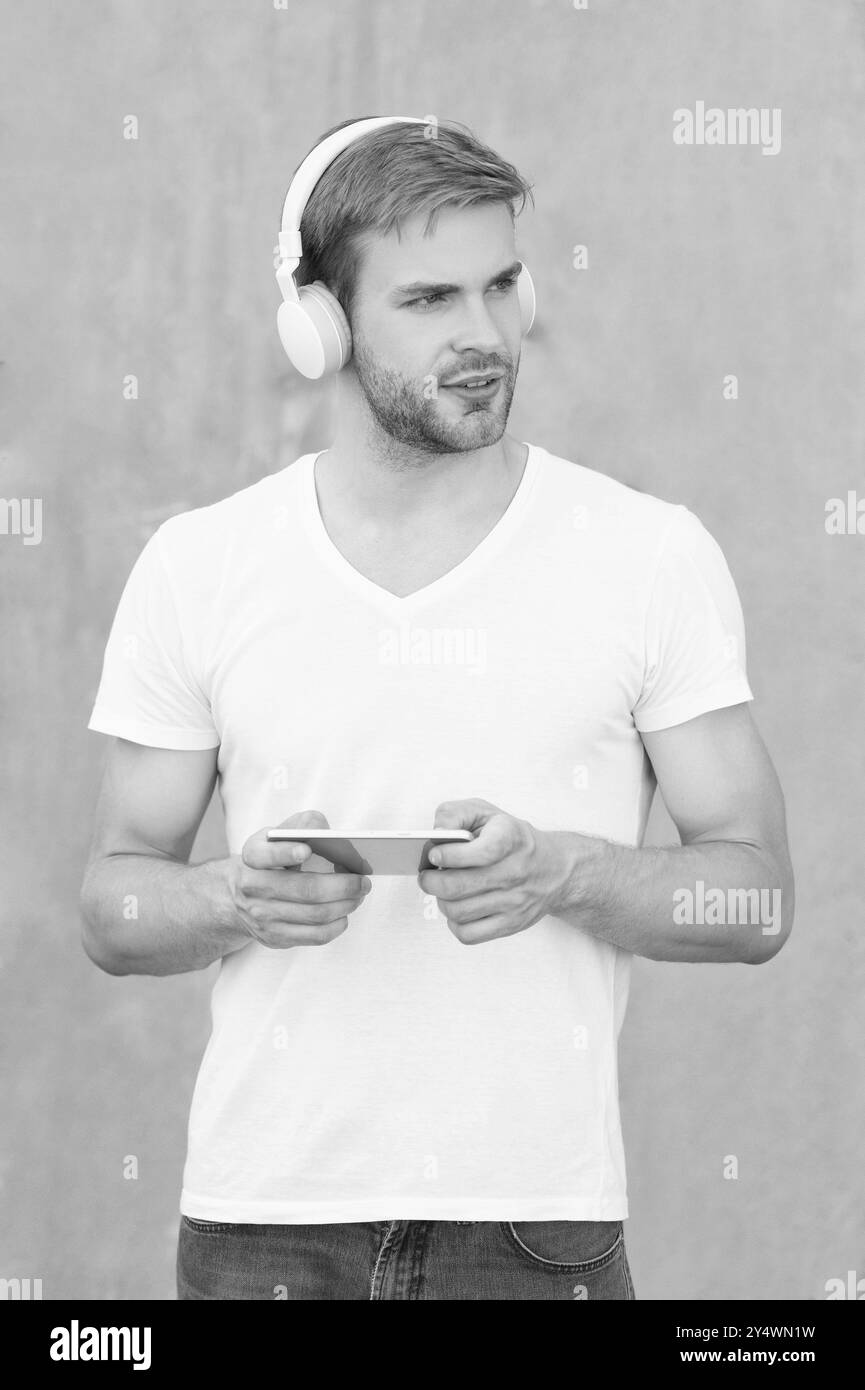 caucasian man choose mp3 music playlist wearing white shirt. photo of ...