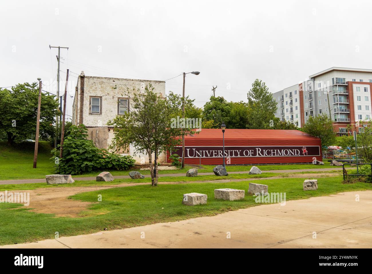A university campus with a red building and a sign that says University ...