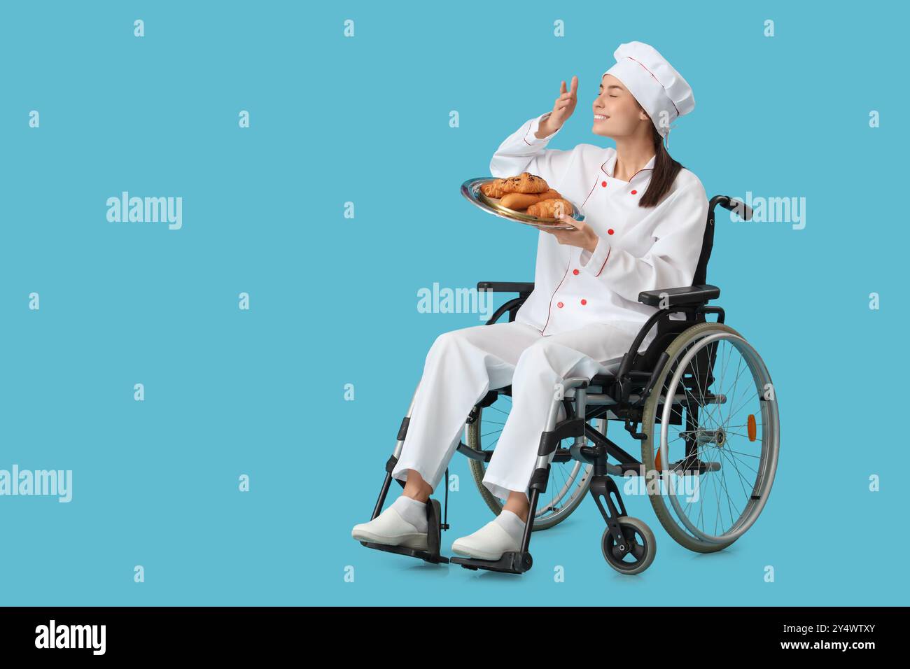 Female chef in wheelchair with croissants on blue background Stock ...