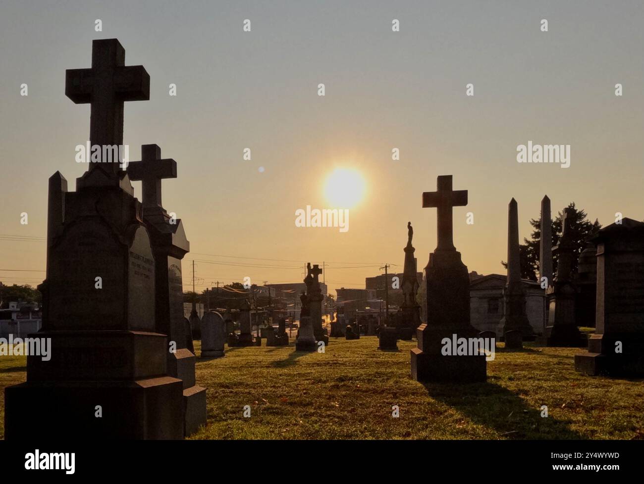 The sun rises behind grave markers in Cathedral Cemetery in West ...