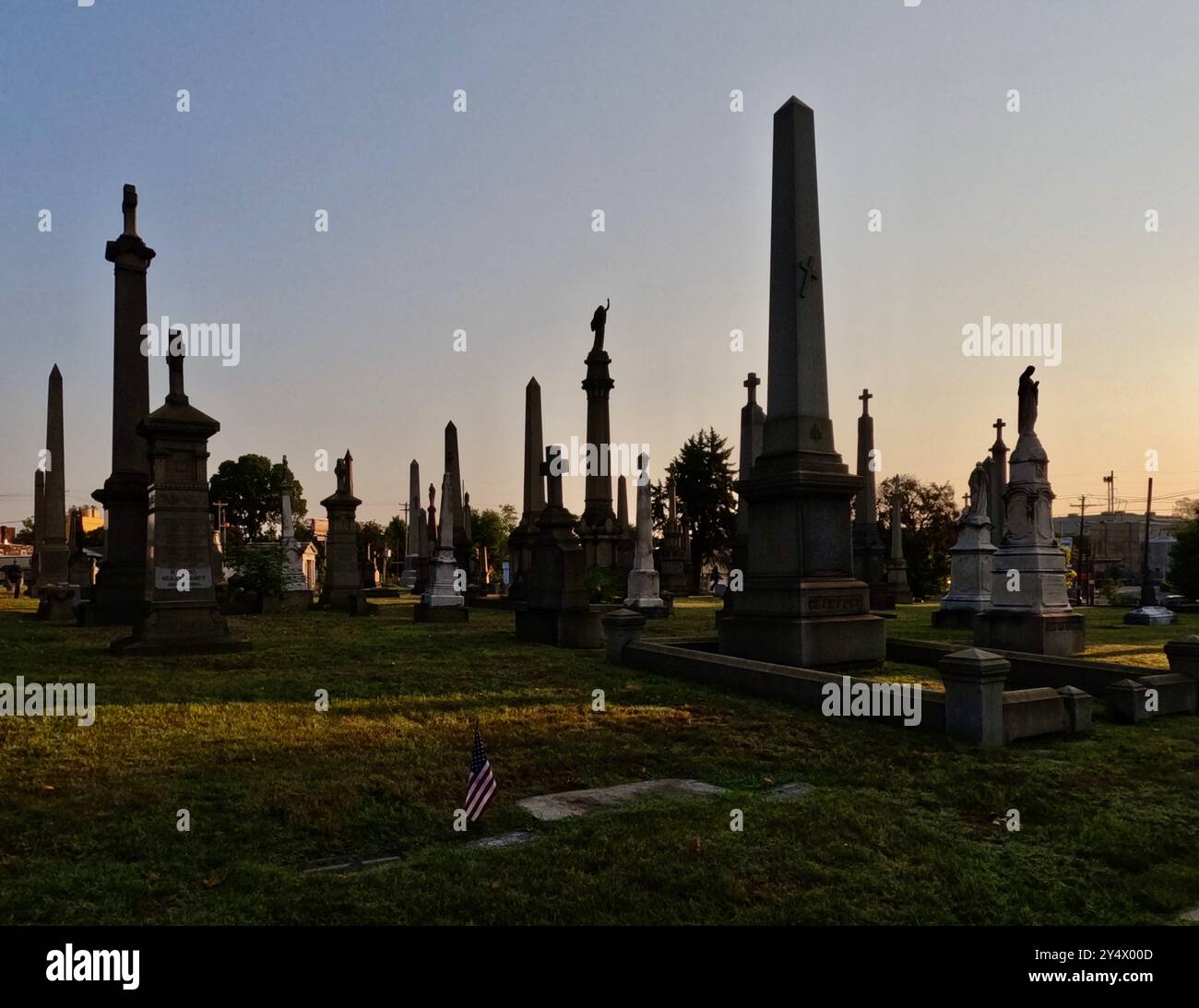 The sun rises behind grave markers in Cathedral Cemetery in West ...