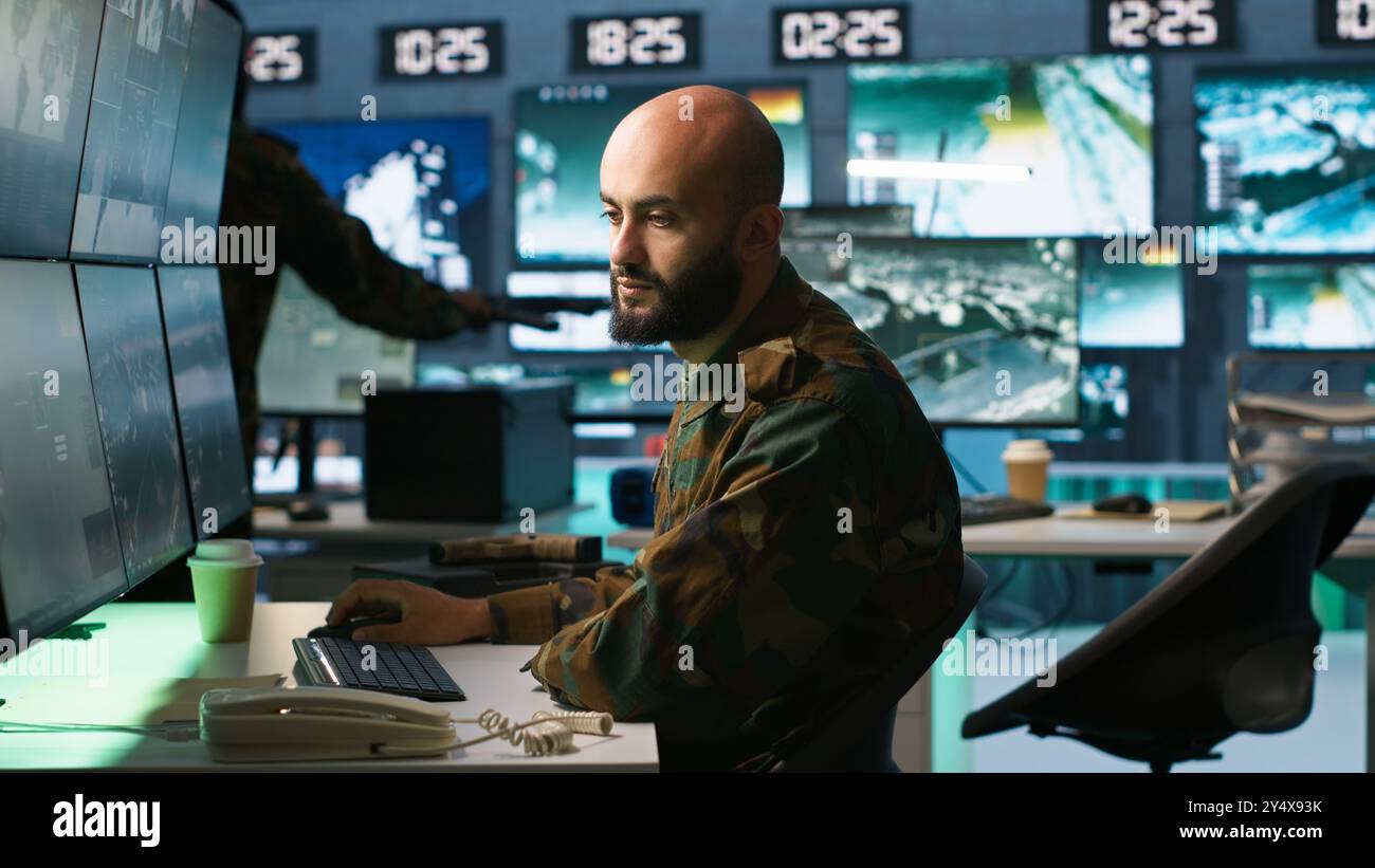 Man looking at screens in military HQ base housing operational missile ...