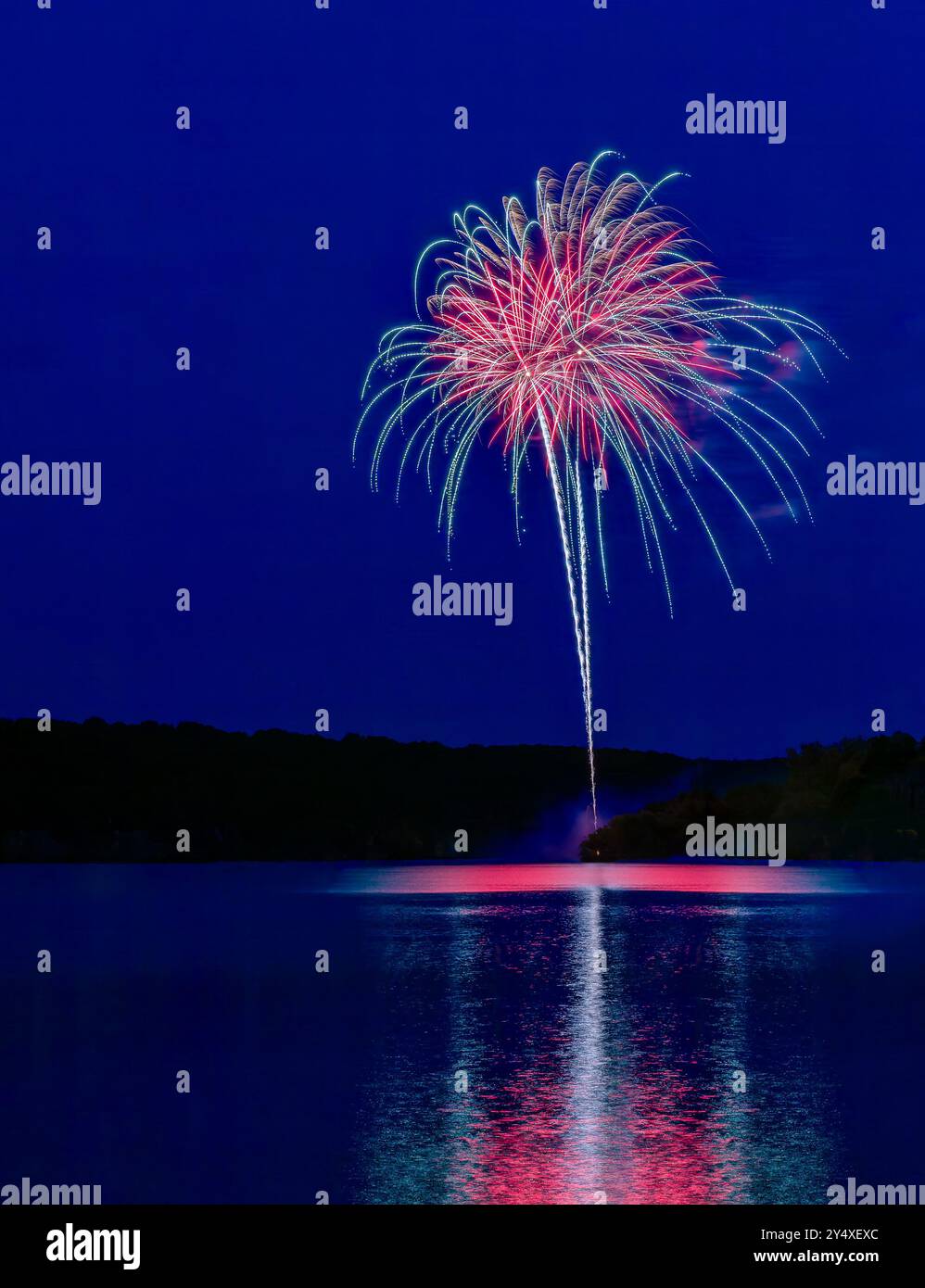 Colorful fireworks exploding over water with red, white, and blue ...