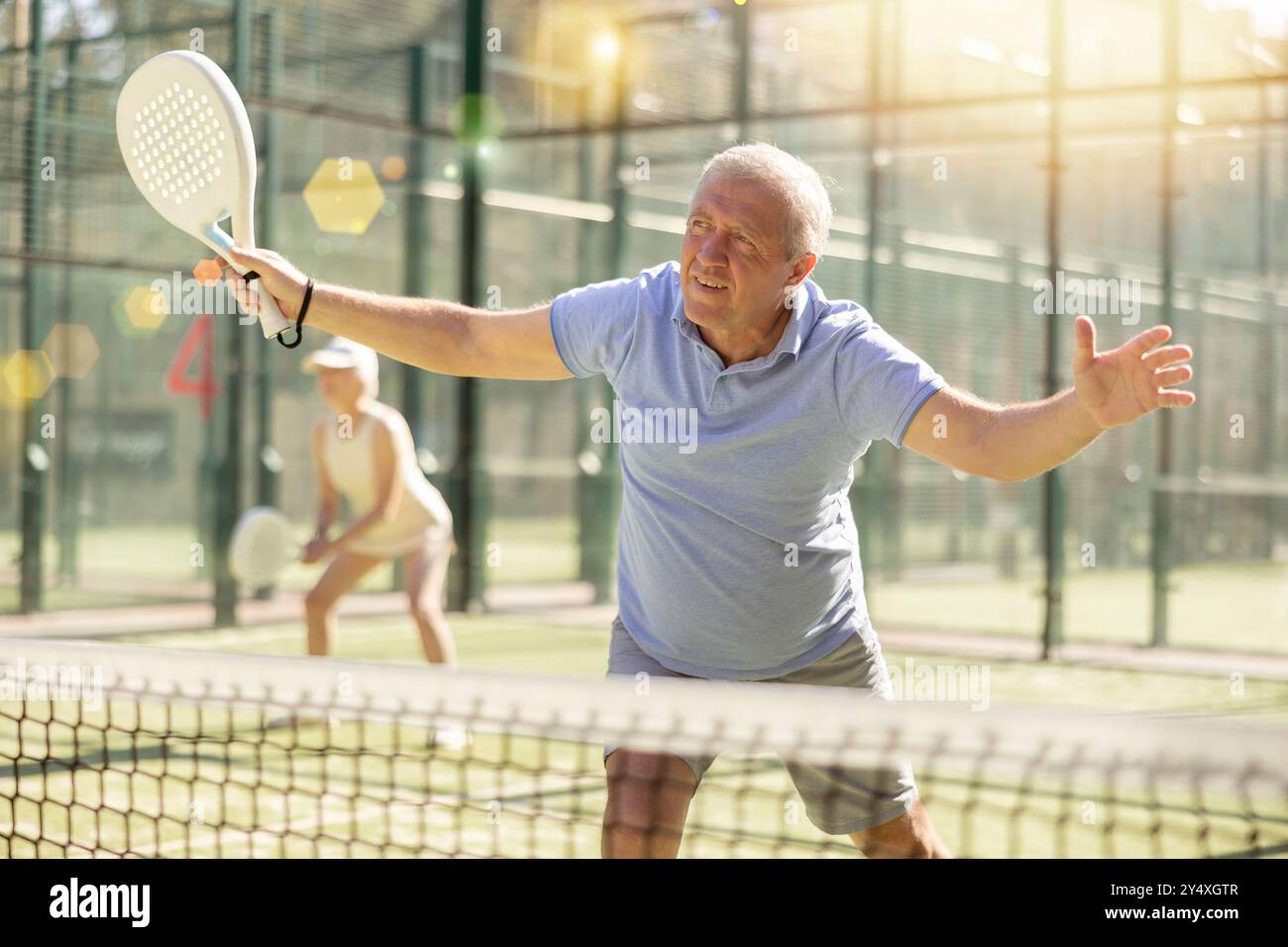 Old man playing Padel Tennis in open-air tennis court Stock Photo - Alamy