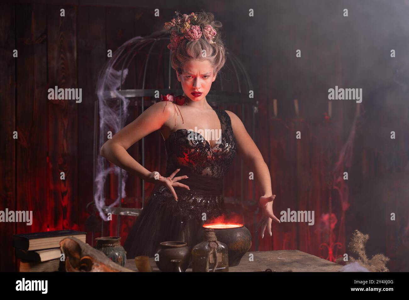 Halloween witch with cauldron. Young woman conjuring, making witchcraft ...