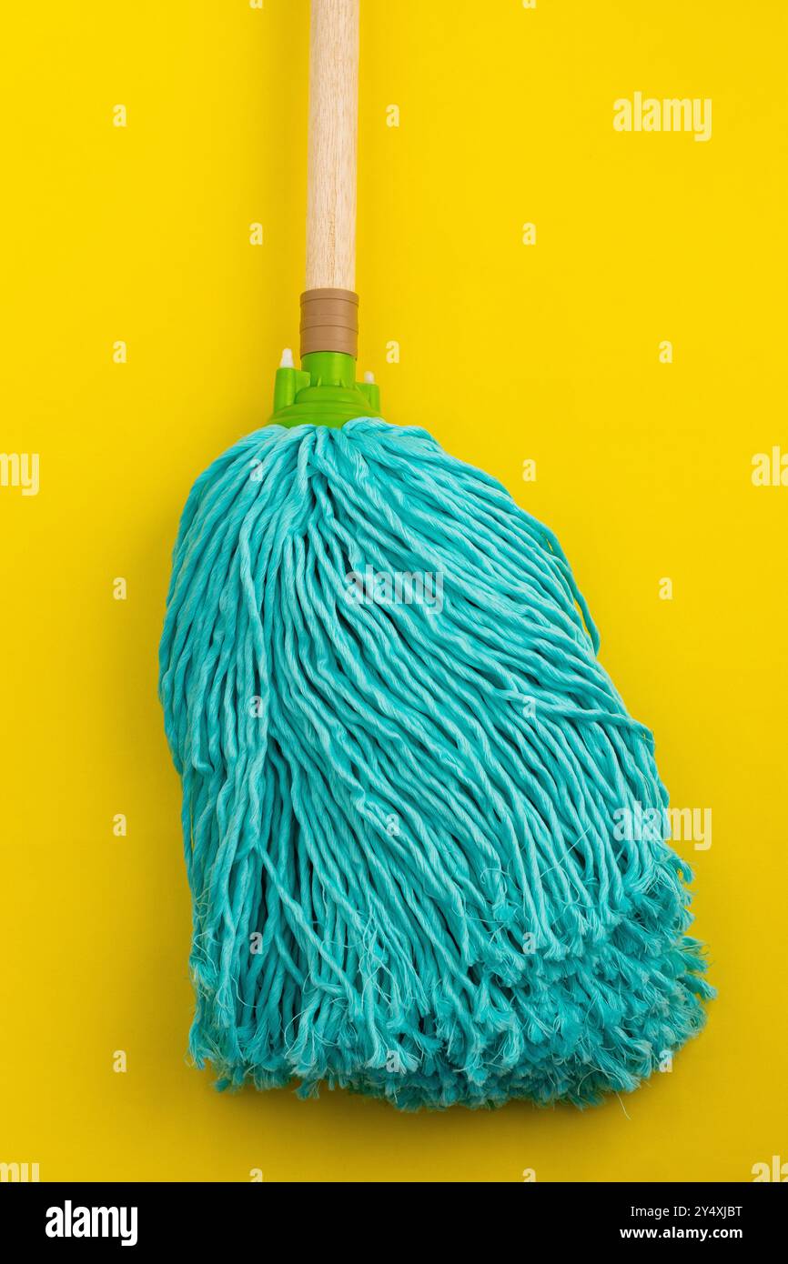 Blue microfiber mop with wooden handle - Yellow background Stock Photo ...