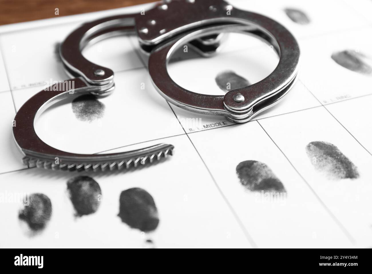 Human fingerprints and handcuffs on paper, closeup. Criminal conviction ...