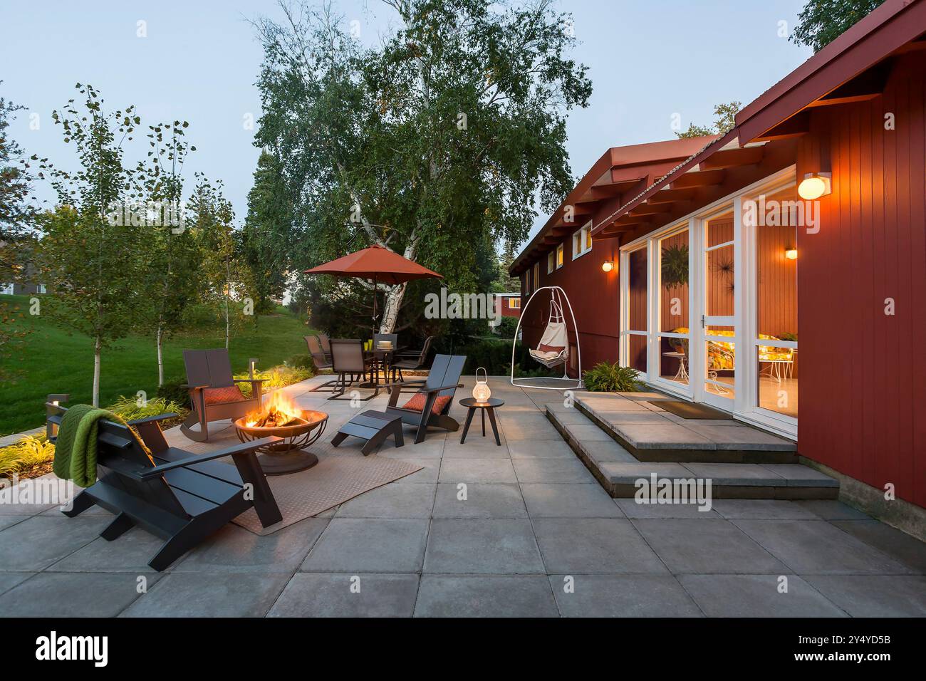 Backyard patio of midcentury rambler photographed at dusk Stock Photo ...