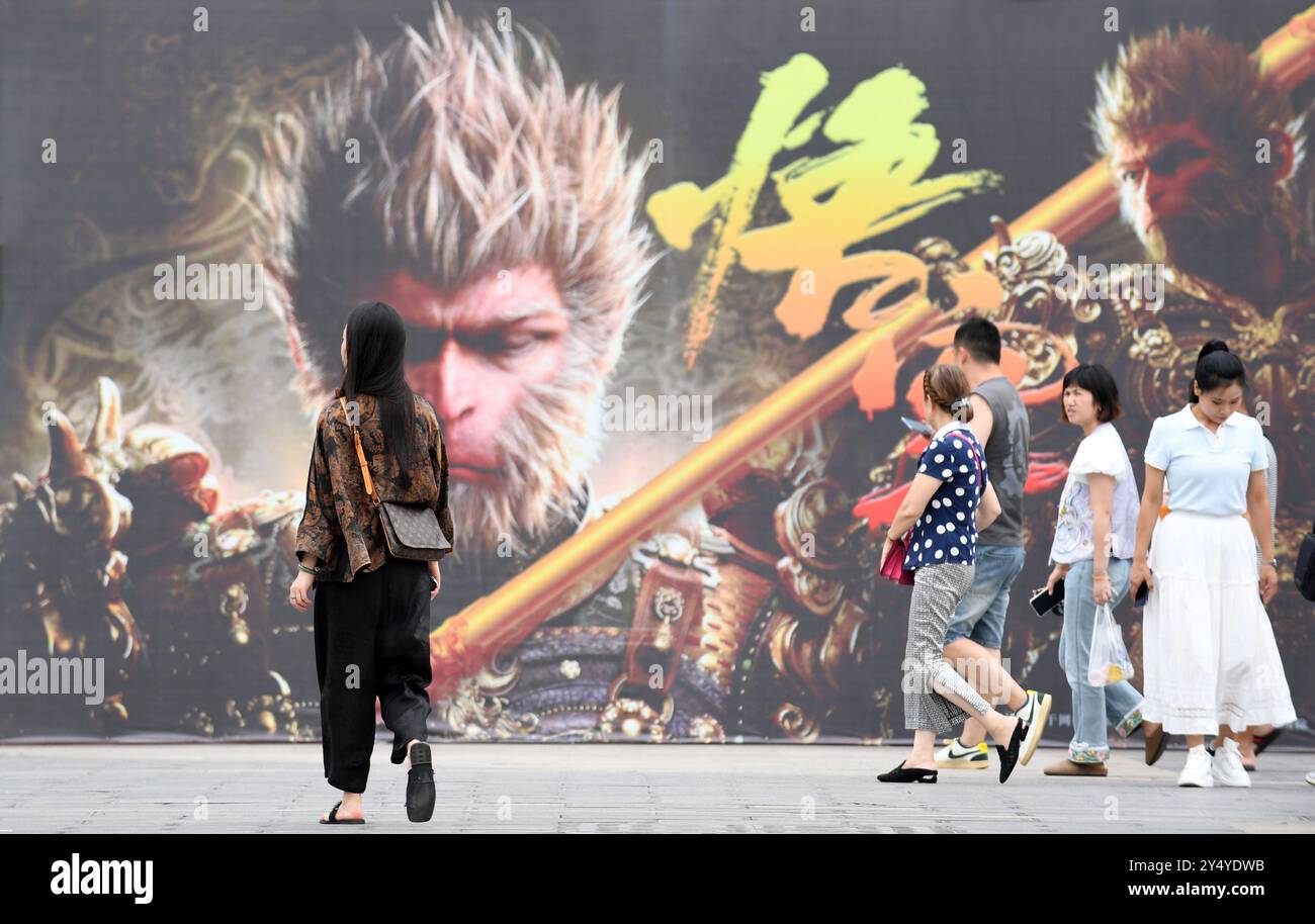RENHUAI, CHINA - SEPTEMBER 15, 2024 - People walk past a poster ...