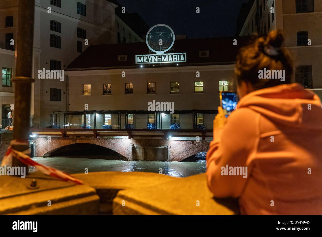 A woman takes photos of an area submerged in water. Wroclaw is ...
