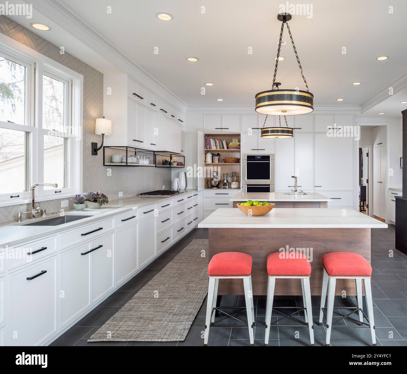 White kitchen with two hickory islands and integrated refrigerator and ...