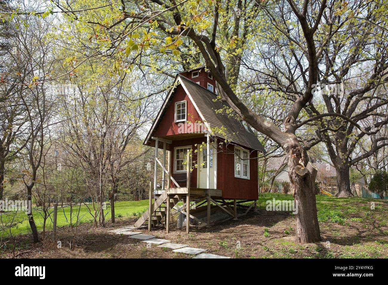 Red shed on stilts surrounded by many trees in early spring Stock Photo ...
