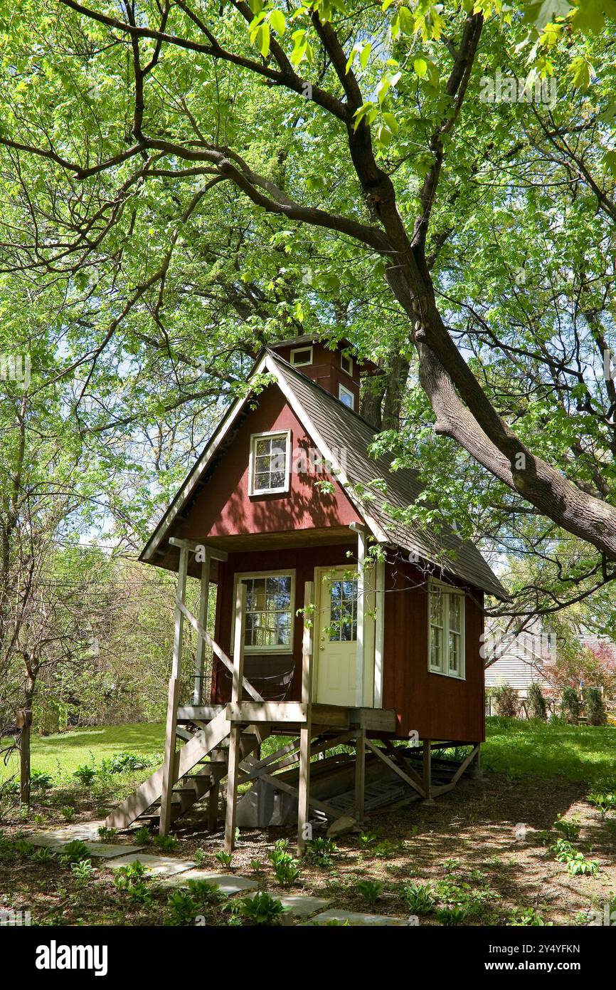 Red shed on stilts surrounded by many trees in late spring Stock Photo ...