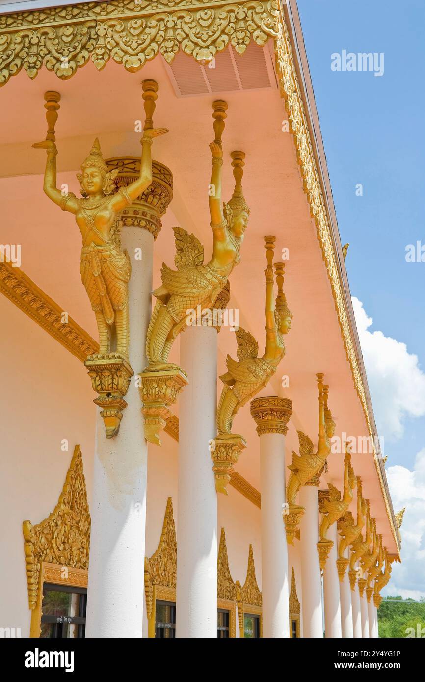 Columns of Buddhist temple are decorated with gilded statues of ...