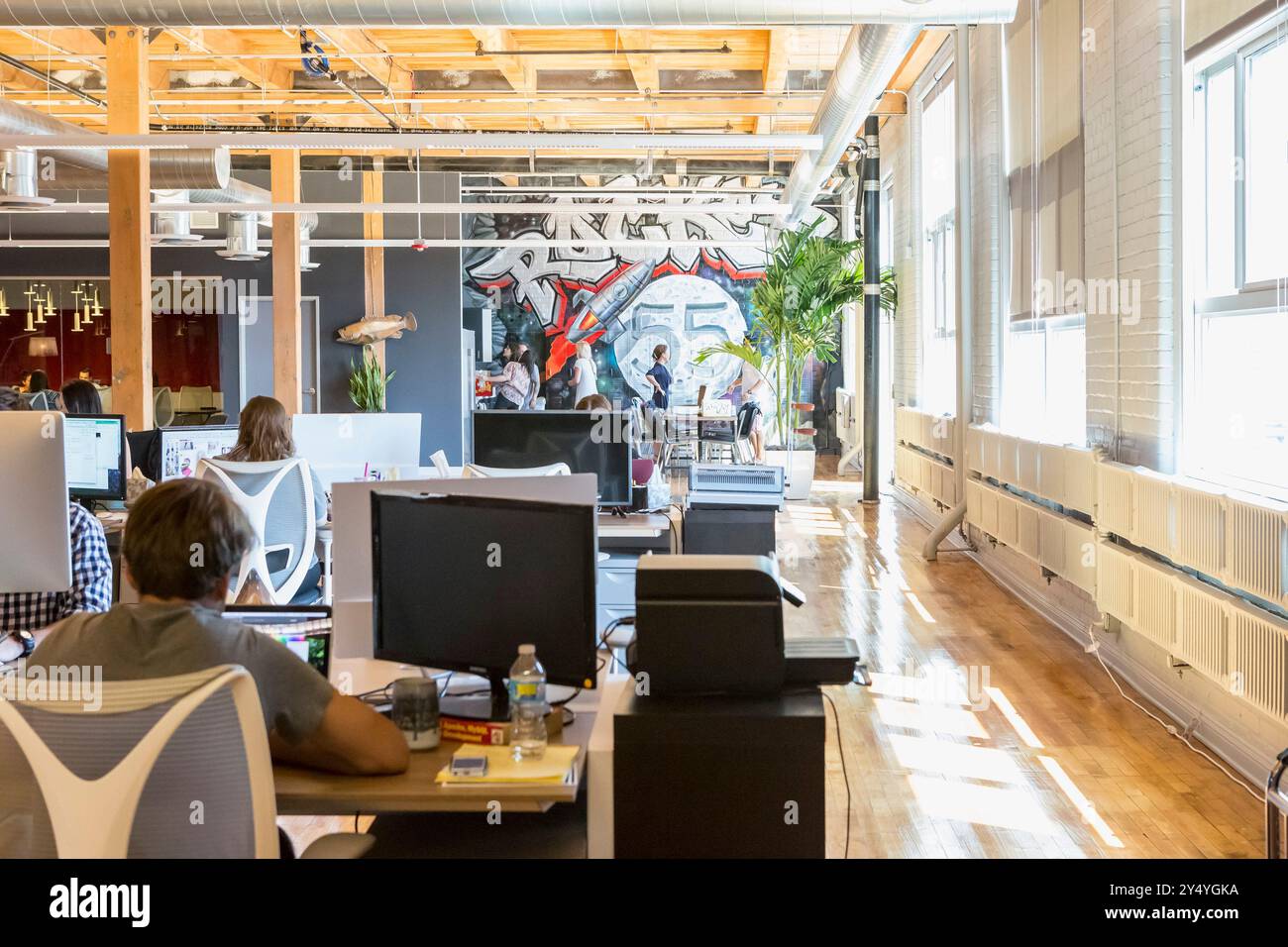 Unique office space in older building with rows of desks and colorful ...