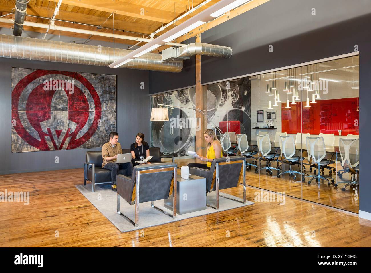 Three people talking in seating area next to conference room Stock ...