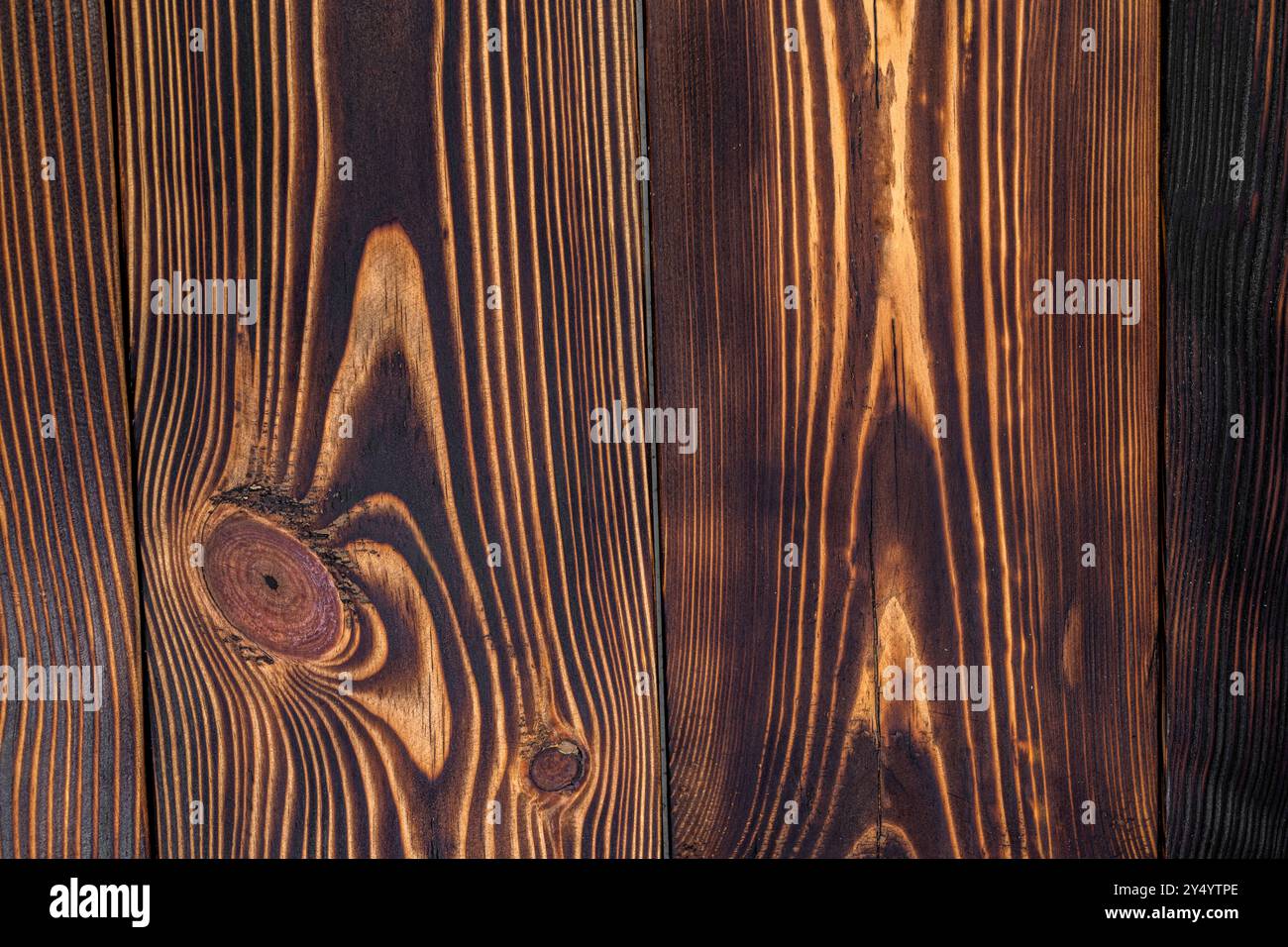 The wood grain is very visible and the wood is burnt. The burnt wood ...