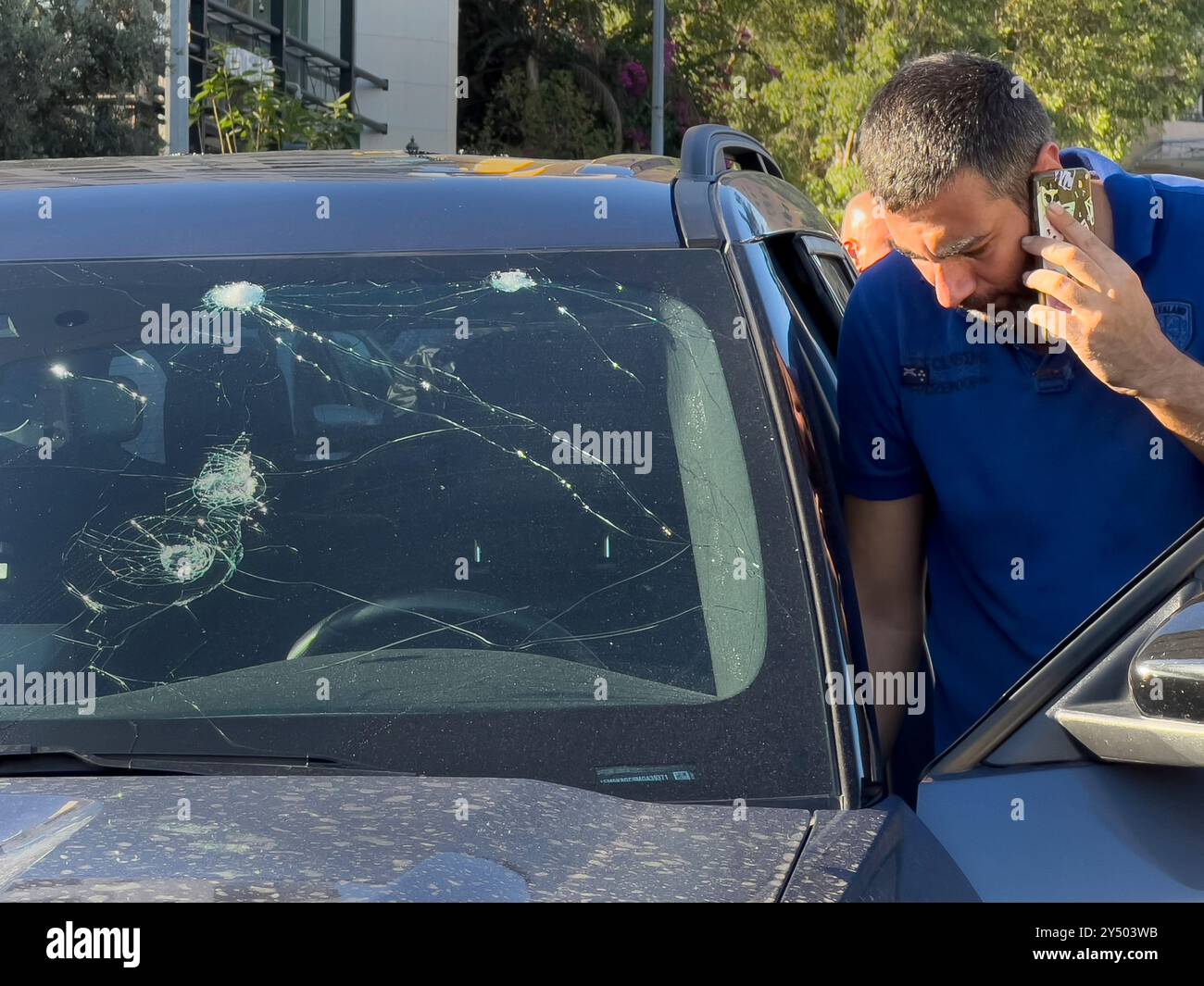 A police officer inspects a car in which a hand-held pager exploded, in ...
