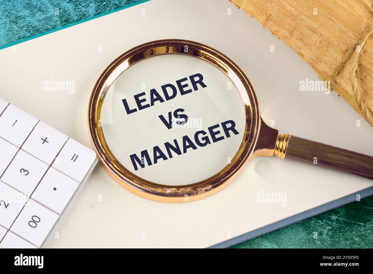 Leader vs manager is shown through a magnifying glass in a business ...