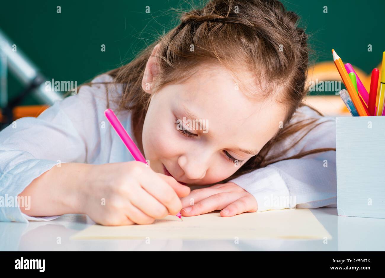 Child girl drawing picture in class. Close up face Stock Photo - Alamy