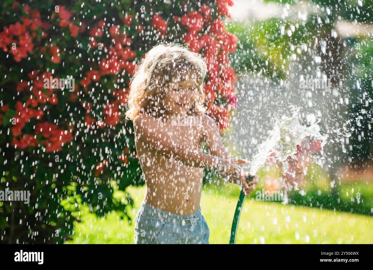 Kids play with water garden hose in yard. Outdoor children summer fun ...