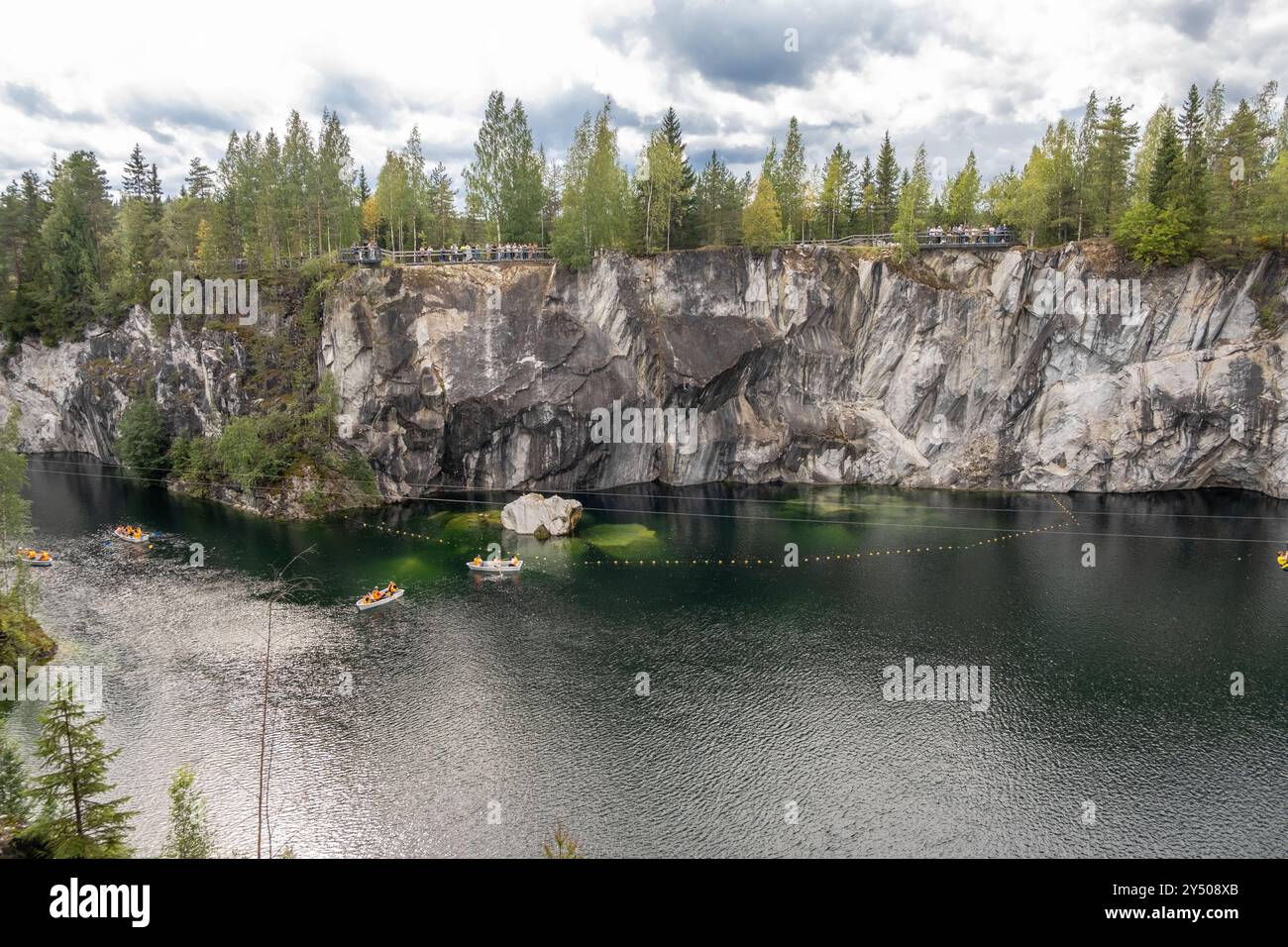 Visitors admire the breathtaking Marble Canyon in Ruskeala Mountain ...