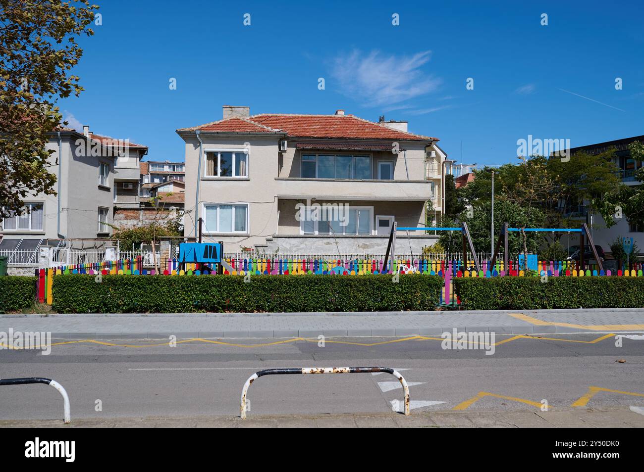 A cheerful playground beside a residential building in a sunny ...