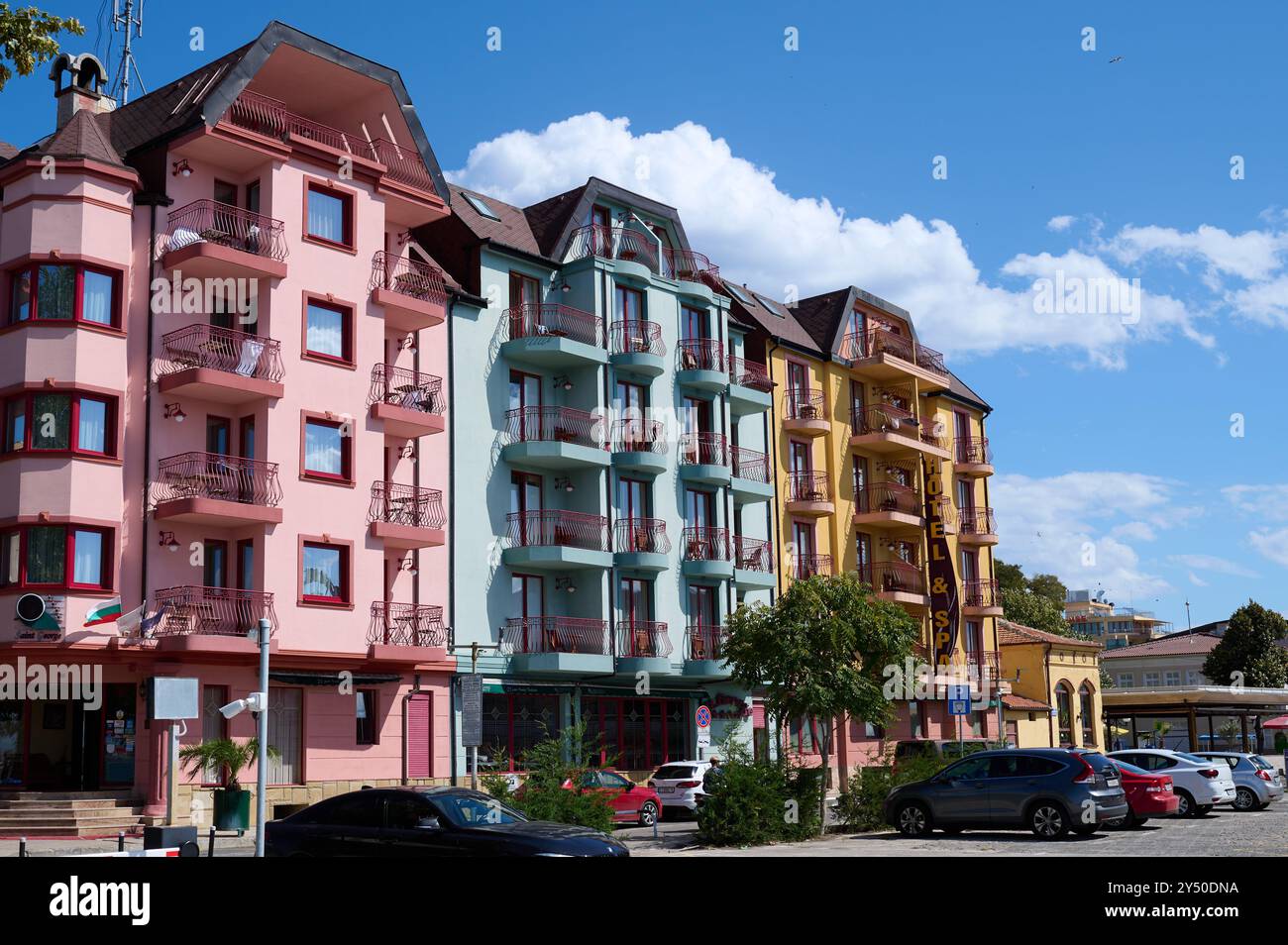 A row of uniquely colored residential buildings stands under a clear ...