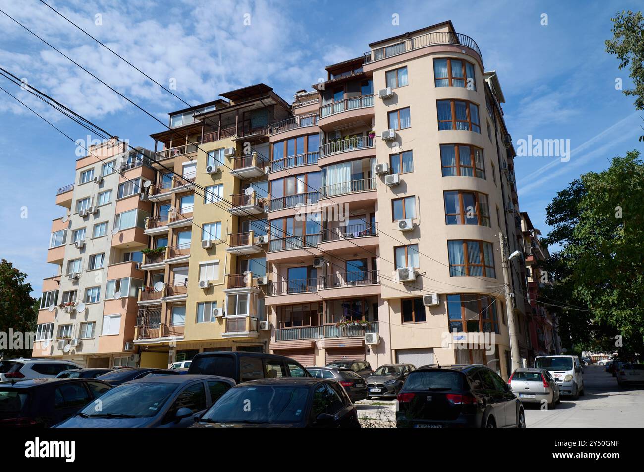 Modern multi-story residential building with balconies and air ...