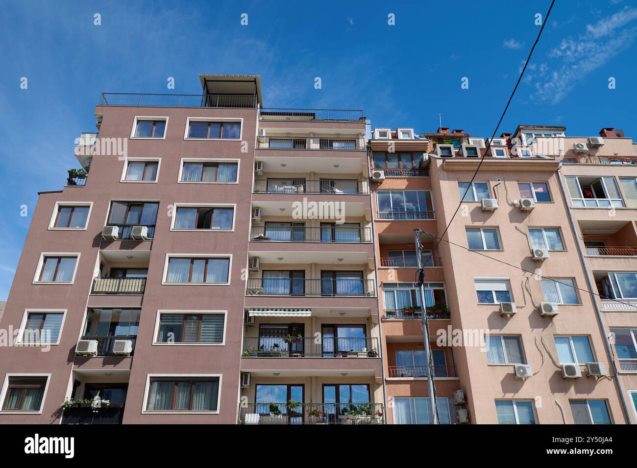 A contemporary residential complex in a bustling city features several ...