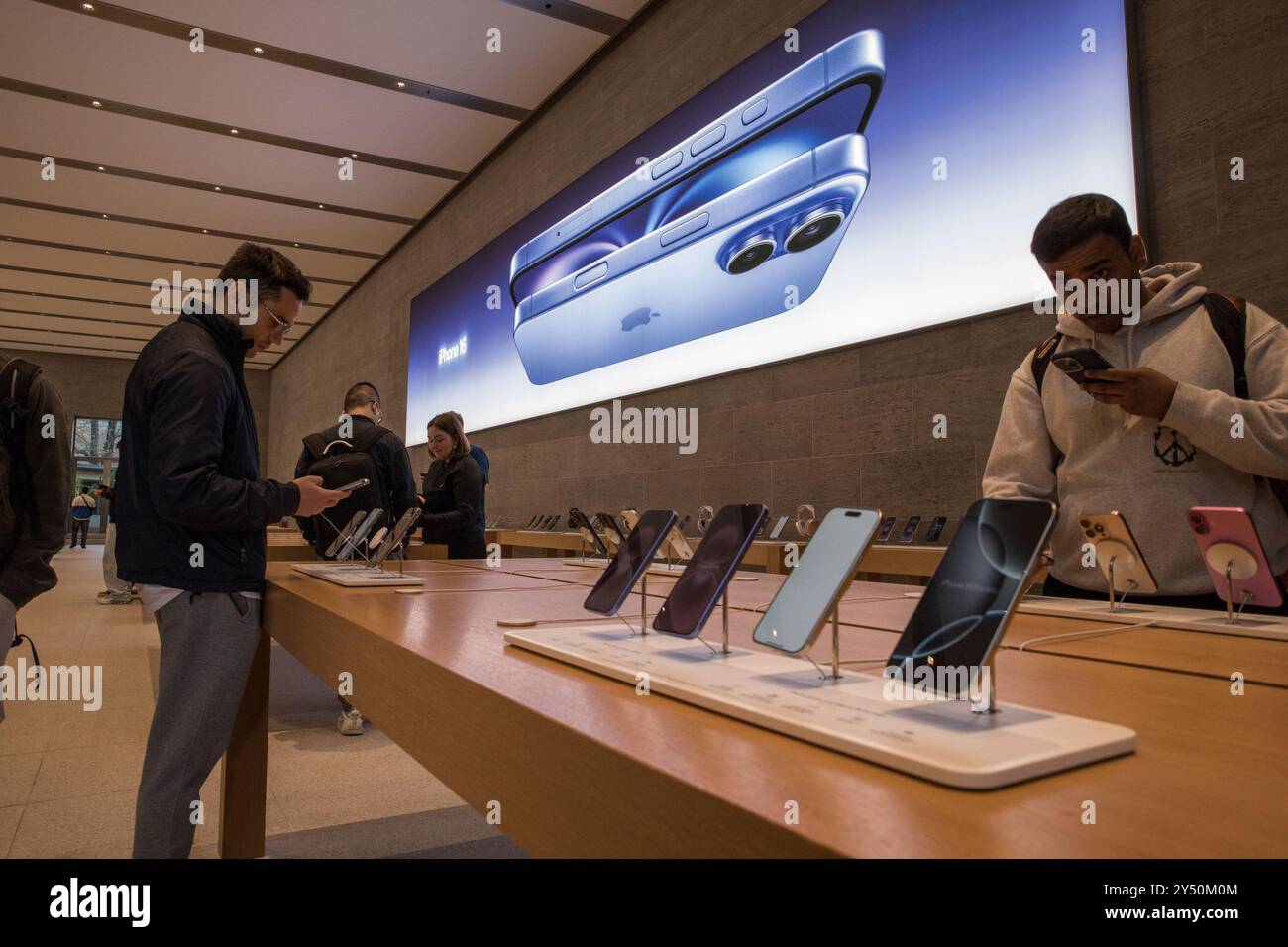 Dozens of eager consumers lined up outside the Apple Store on ...