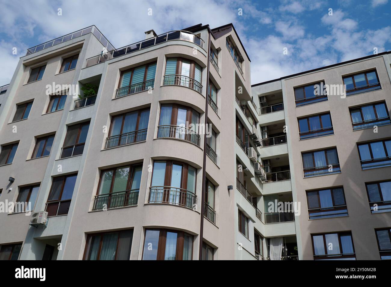 Modern apartment building with curved facade and numerous windows under ...